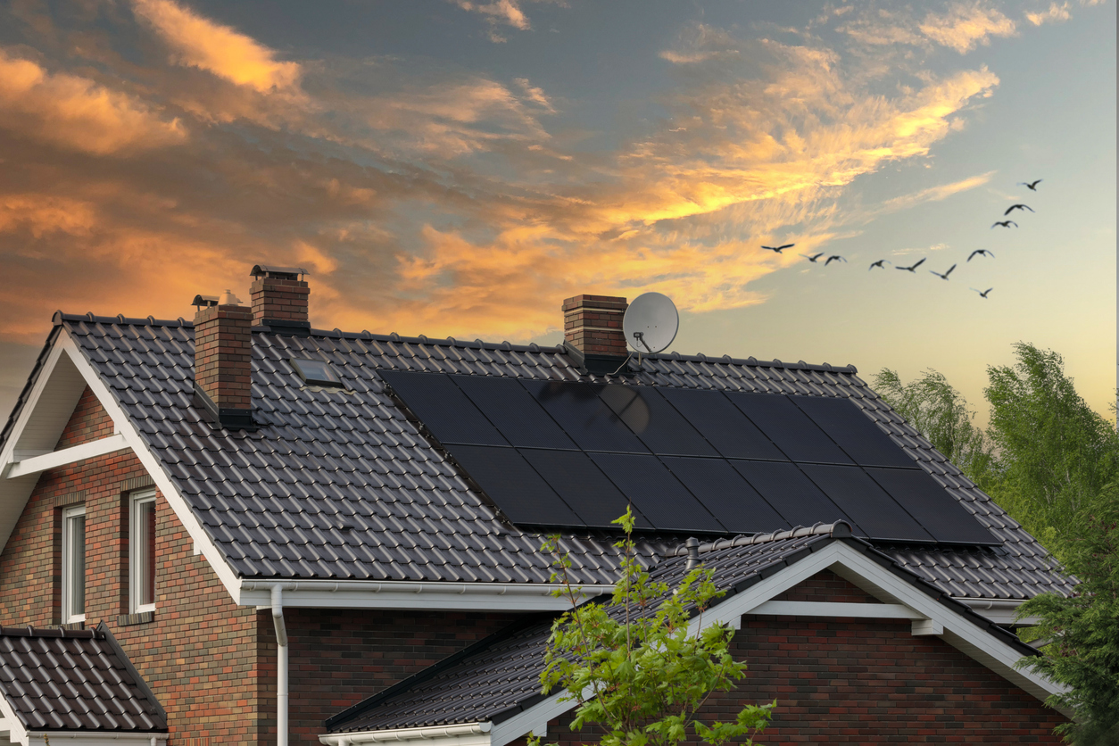 Brick house, solar panels, beautiful sunset. Roof and photovoltaic ...